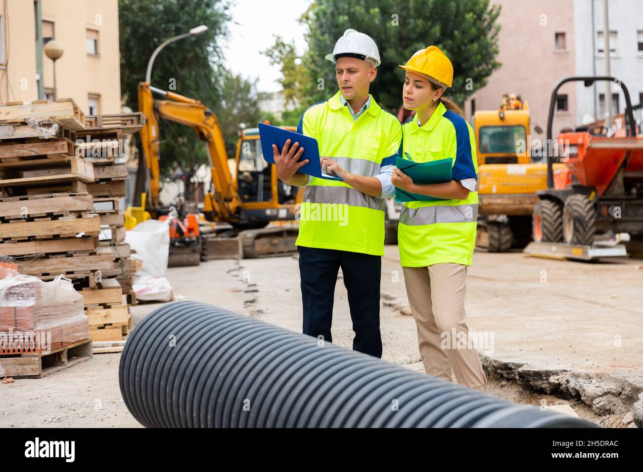 Man and woman engineers in construction site Stock Photo - Alamy