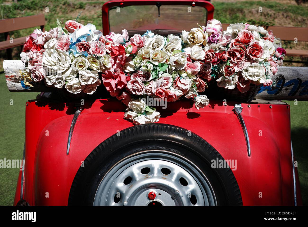 Classic old style of unuse red car and hanging black tire wheel on back ...