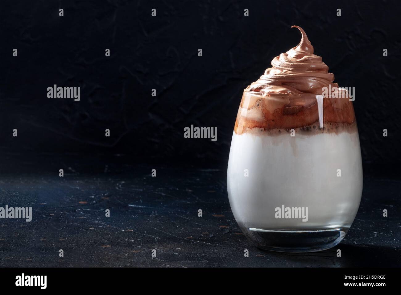 Dalgona cold coffee on a black background with copy space. Sweet Korean ...