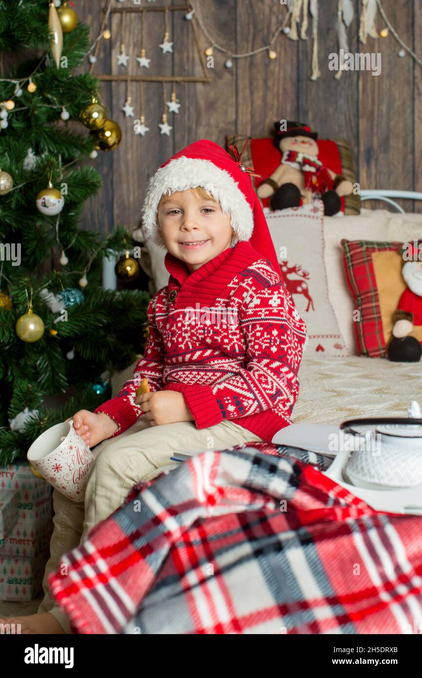 Cute toddler child, boy in a Christmas outfit, playing in a wooden ...