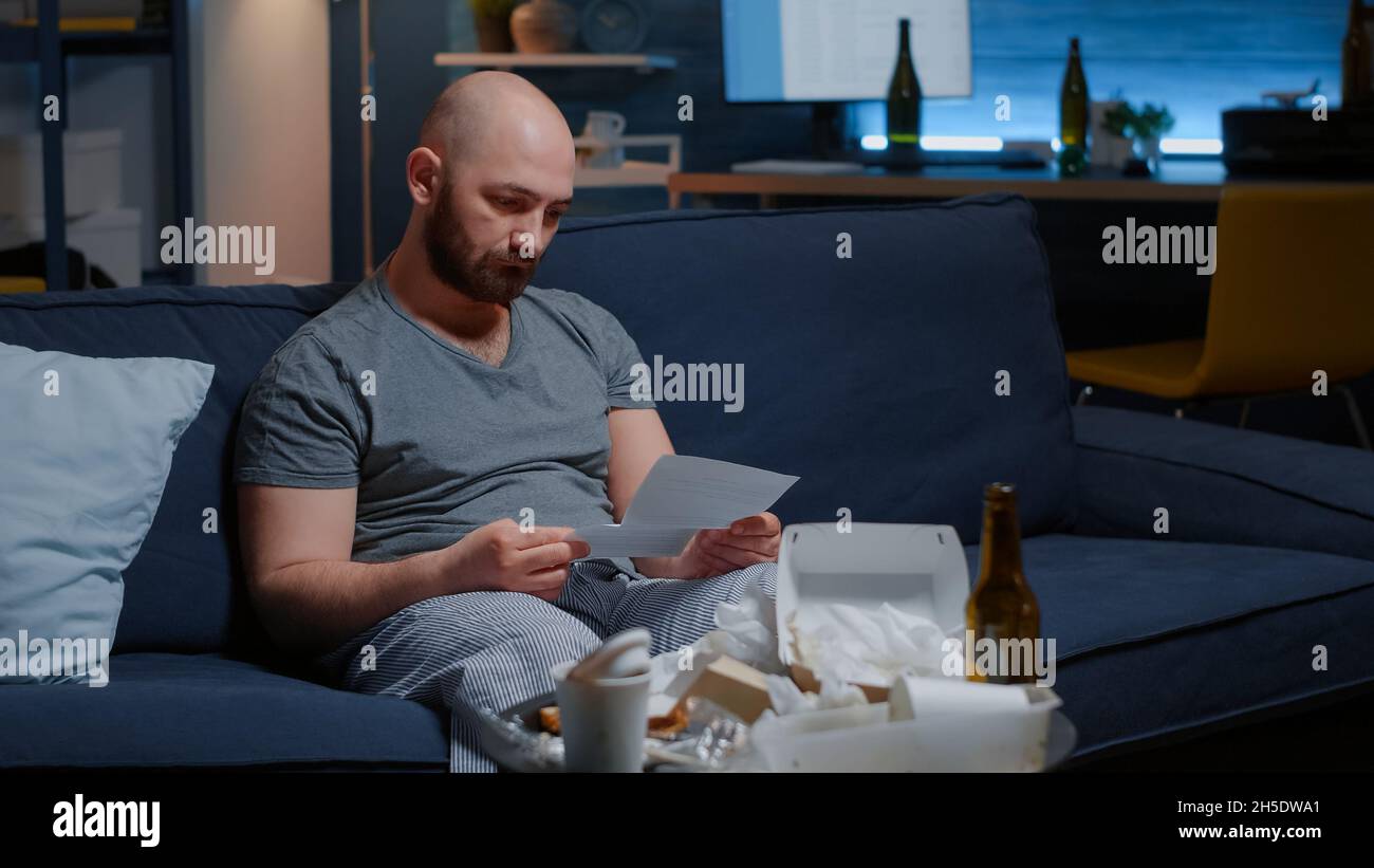 Sad annoyed man reading eviction notice holding paper letter feeling ...
