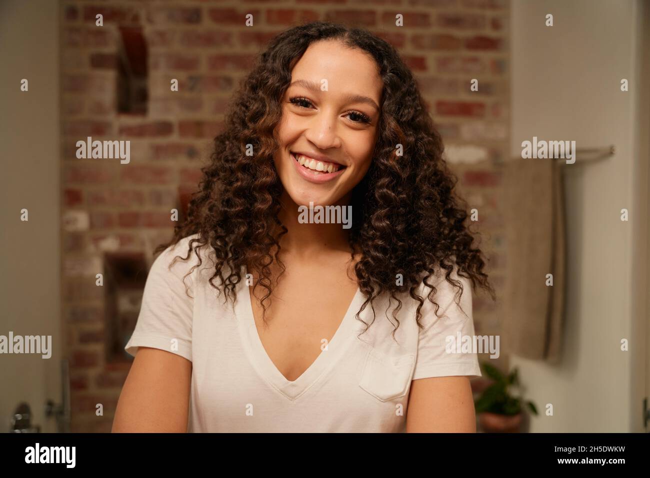Multi-cultural young adult female happily looking at reflection in ...
