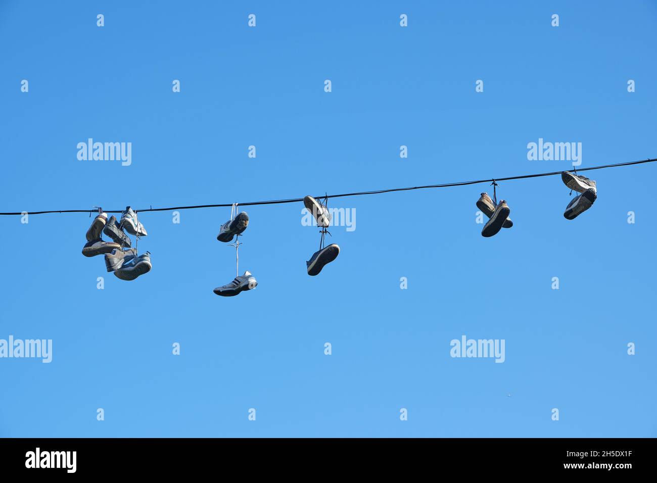 Sports shoes are hanging on wires.Sneakers suspended by laces on ...