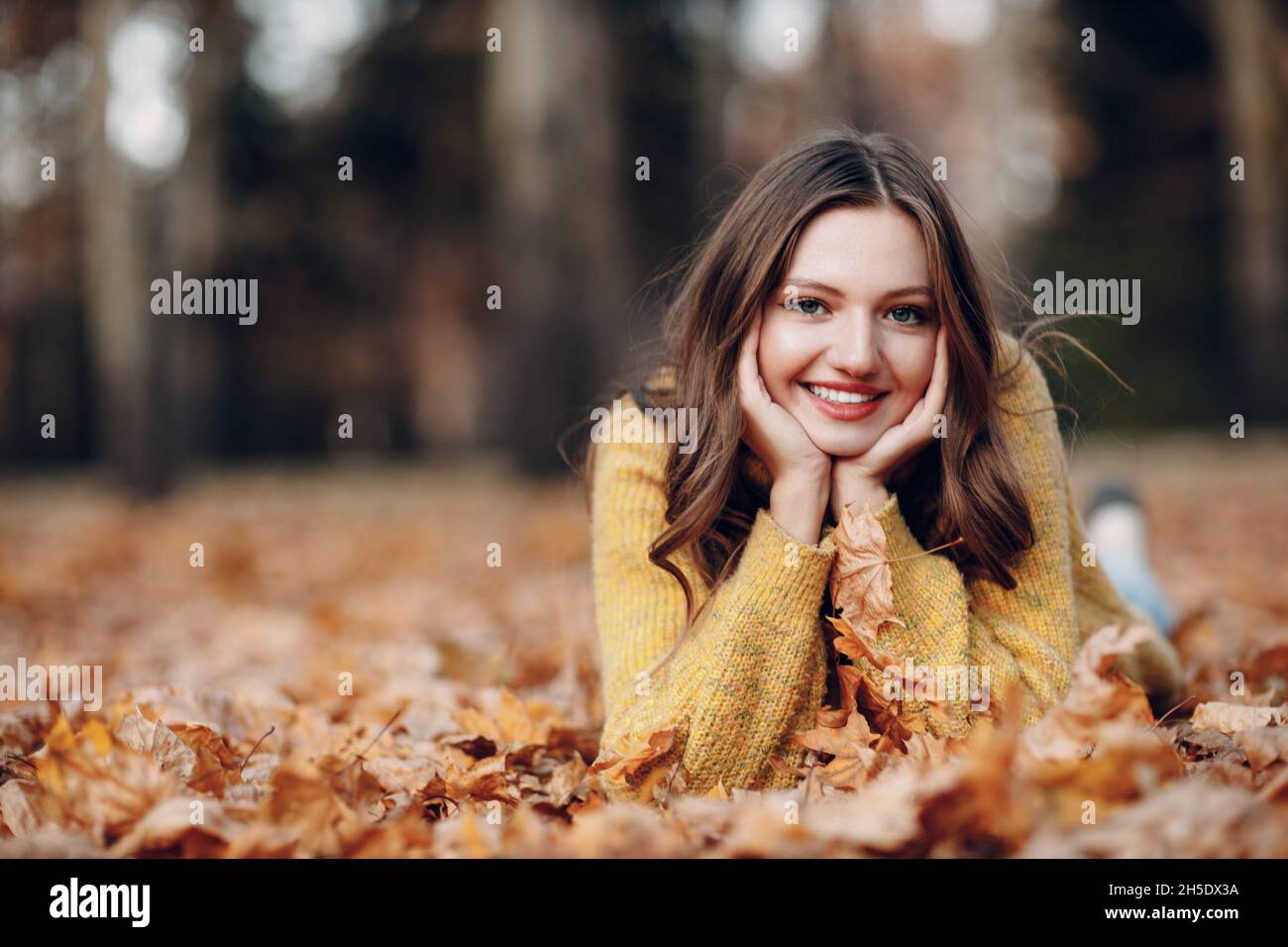 Woman lying in fall leaves hi-res stock photography and images - Alamy