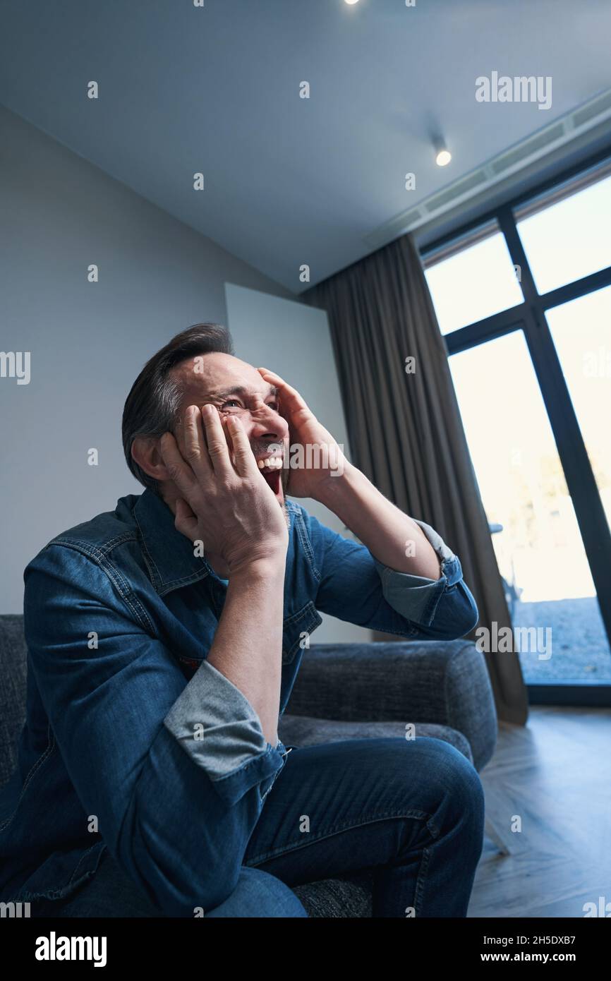 Unhappy male screaming alone at home with pain Stock Photo - Alamy