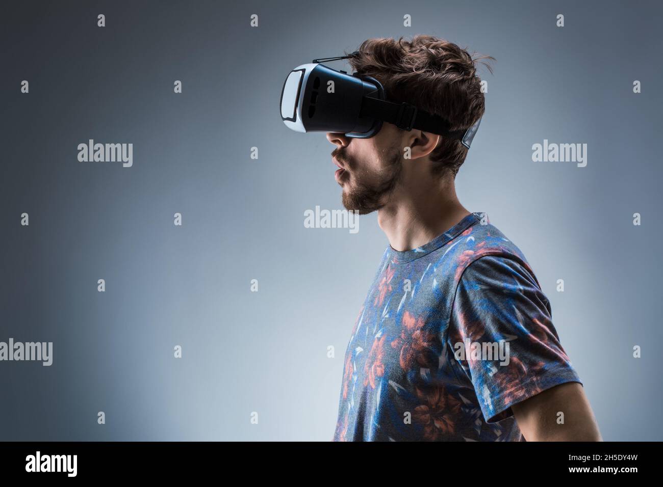 Side view of a young guy using a VR headset. Emotions Stock Photo - Alamy