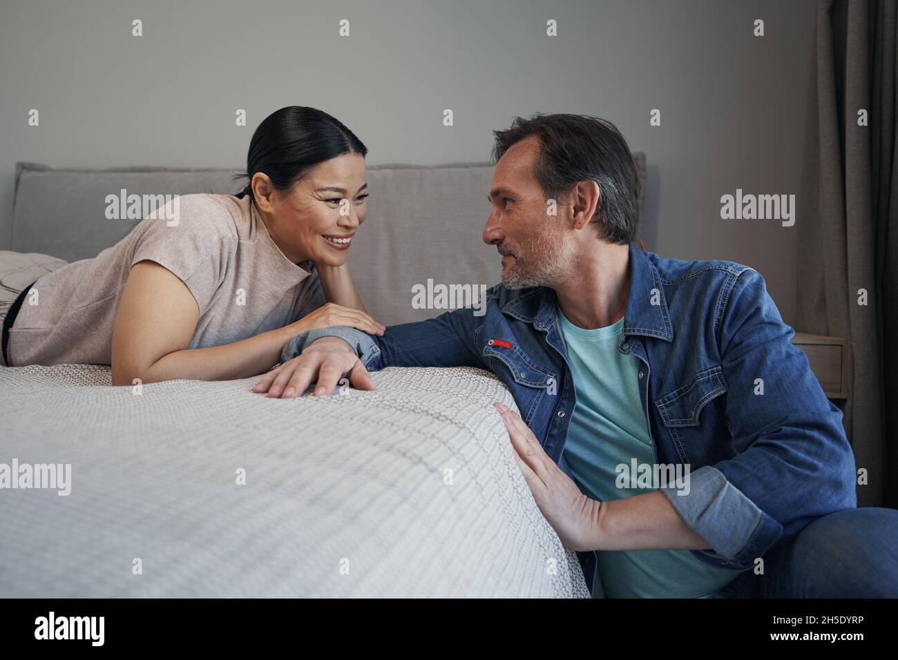 Joyful married mature couple communicating in bedroom Stock Photo - Alamy