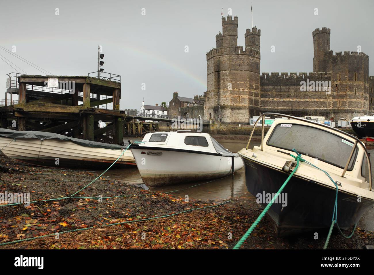 Caernarfon Castle at low tide with a faint rainbow alongside, Gwynedd ...