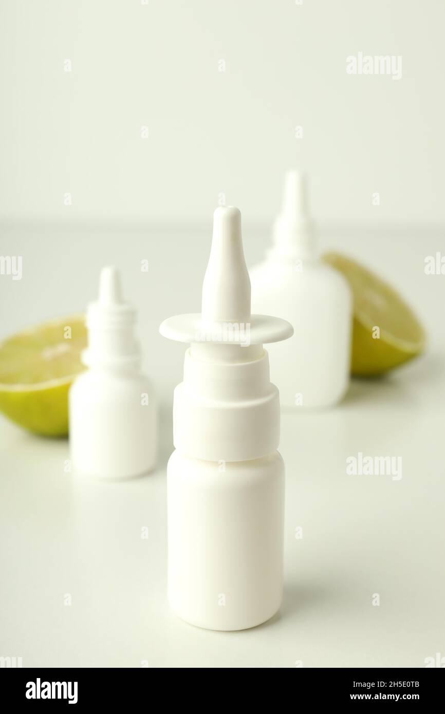 Blank bottles of nasal spray and lime halves on white table Stock Photo ...
