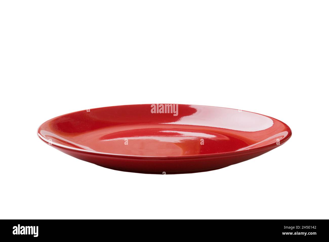 Red ceramic round plate isolated over white background. perspective ...