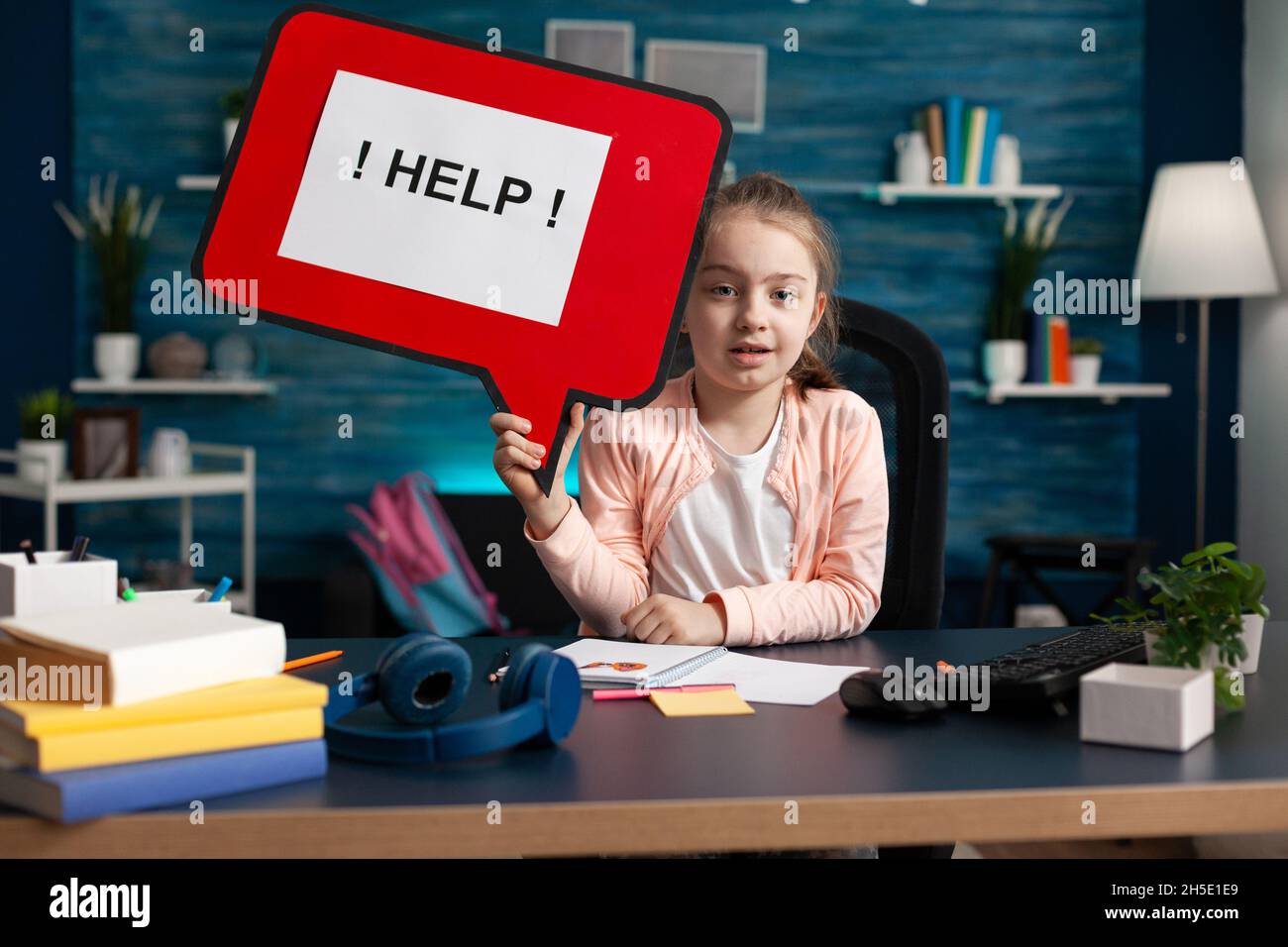 Portrait of schoolkid struggling with school problem while working at ...