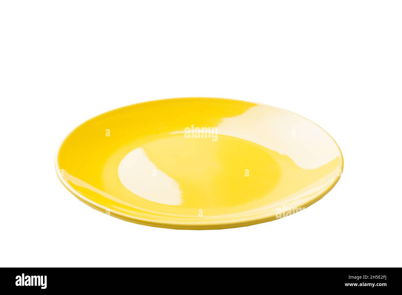 Yellow ceramic round plate isolated over white background. perspective ...