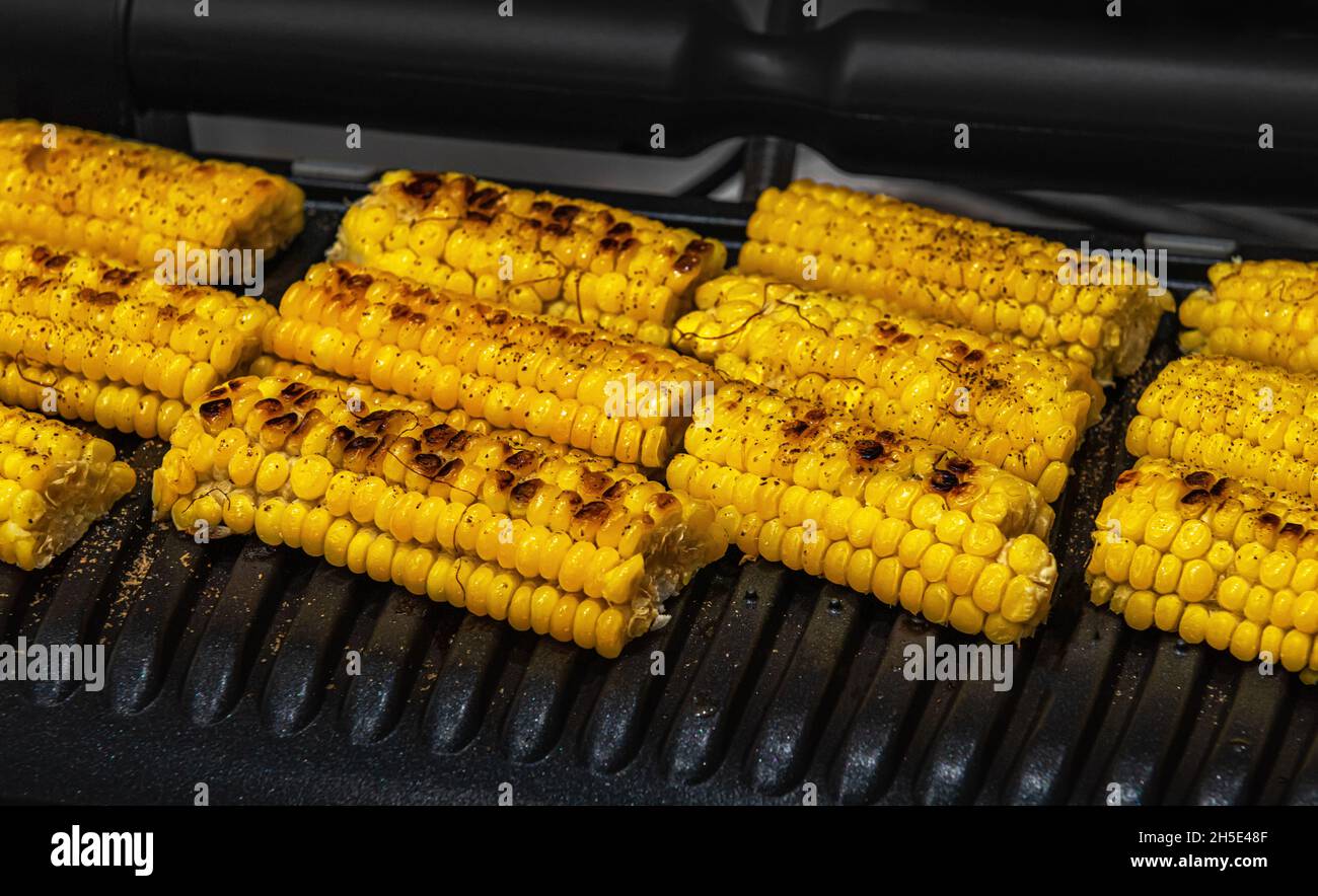 Close-up of slices of ready to eat grilled tasty yellow sweet corn cobs ...