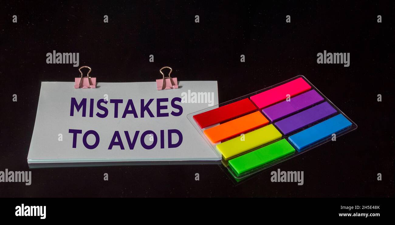A notepad with the text Errors to Avoid lies on a black background with ...