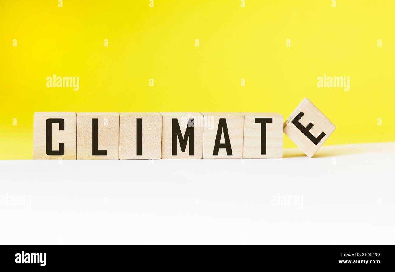 Close up word CLIMATE on wooden cubes and yellow and white background ...