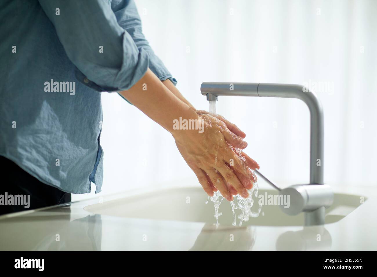 Japanese man washing hands in the kitchen Stock Photo - Alamy