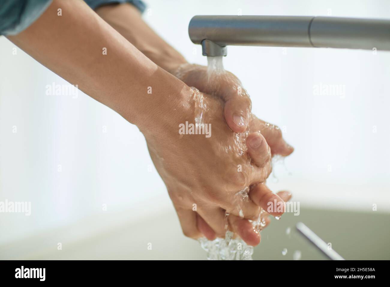 Japanese man washing hands in the kitchen Stock Photo - Alamy