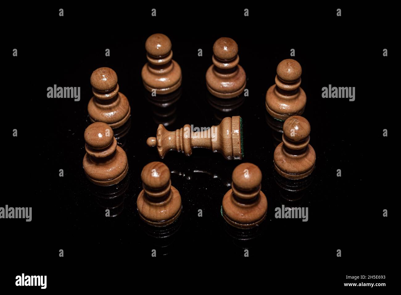 Pawn round and fallen queen black background with reflection Stock ...