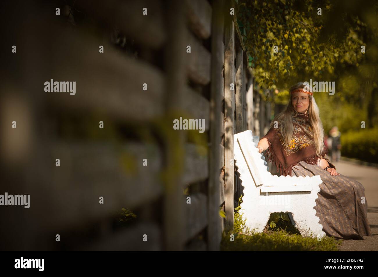 Girl in folk costume sitting on a bench in Konstantinovo Stock Photo ...