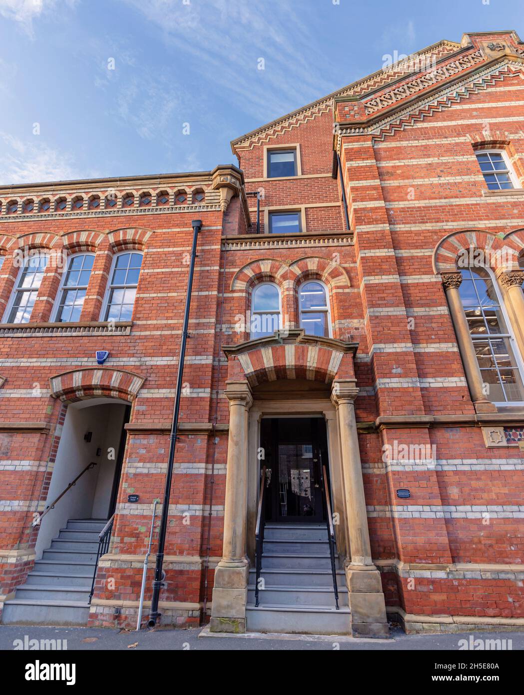 An ornate office building in red brick with white brick in layers. The ...