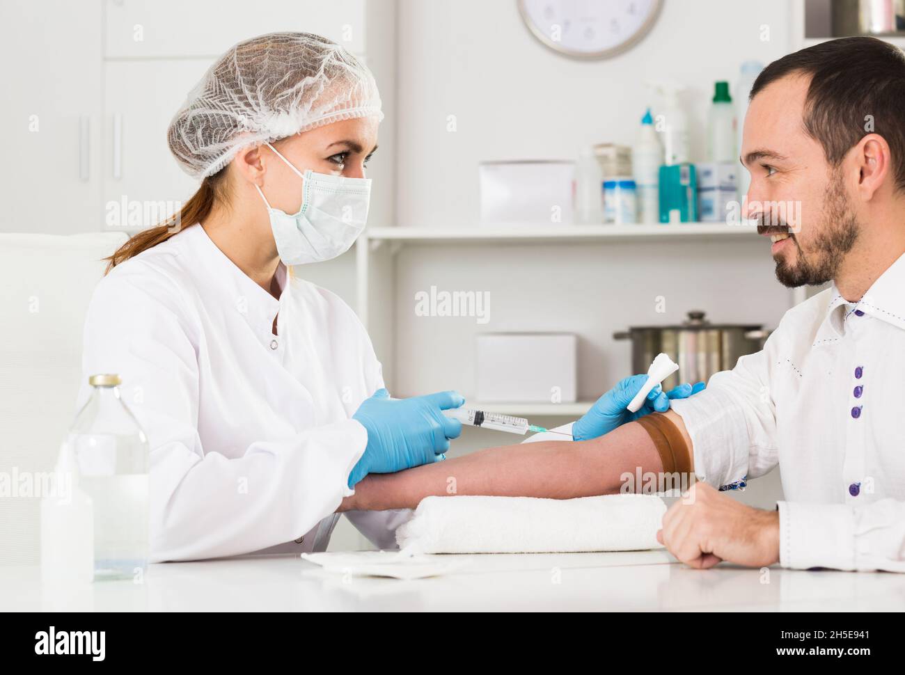 Female nurse injecting male patient Stock Photo - Alamy