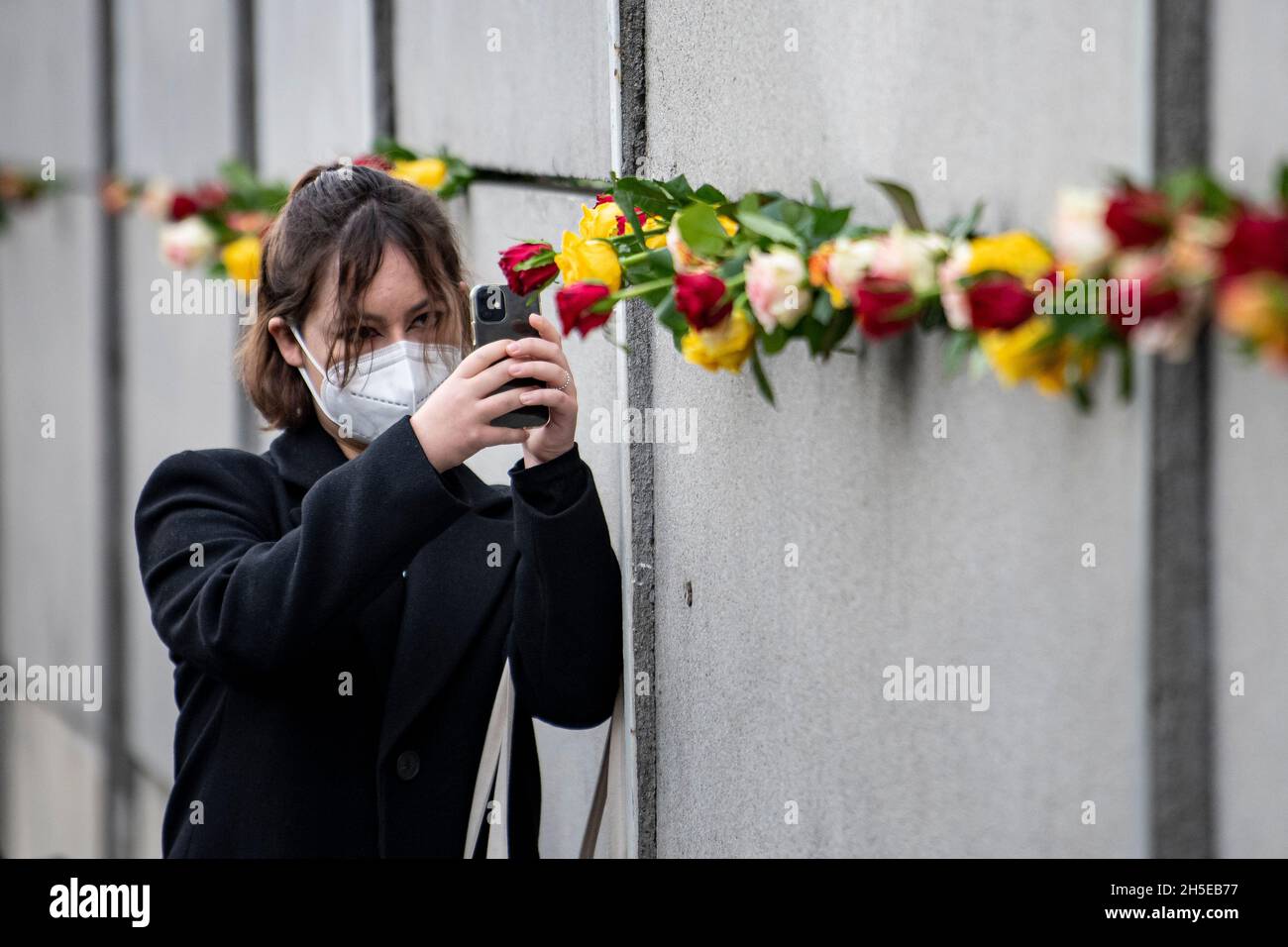 Berlin, Germany. 09th Nov, 2021. A young woman takes a photo of roses ...
