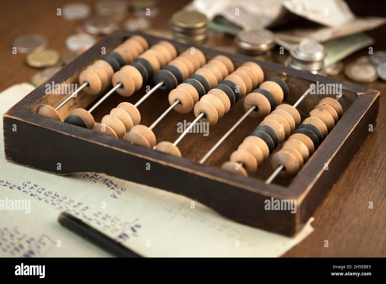 Vintage wooden abacus on the wooden table with paper with calculations ...