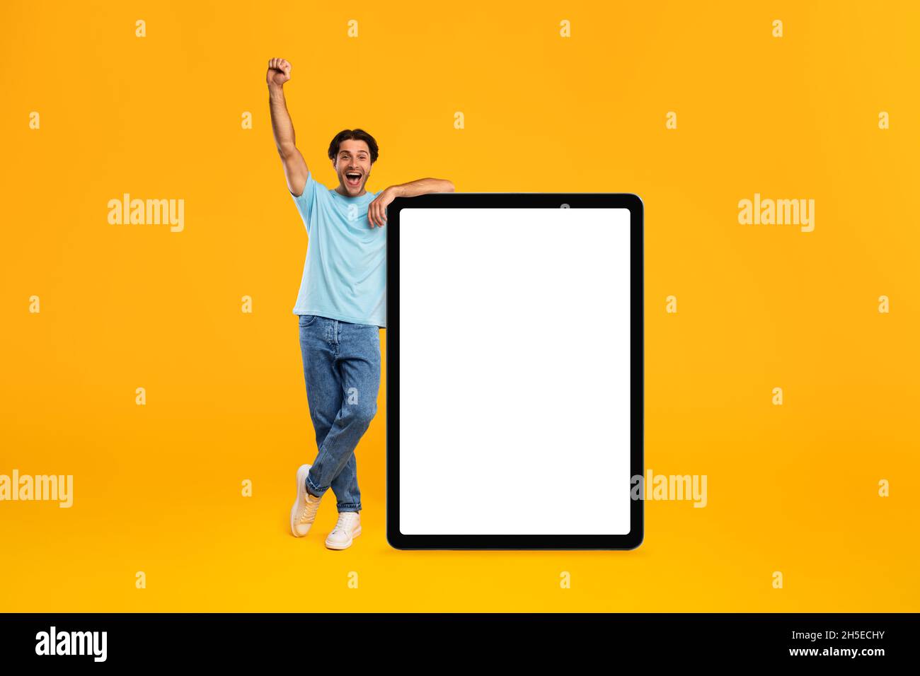 Yes. Man leaning on blank empty tablet screen celebrating success Stock ...
