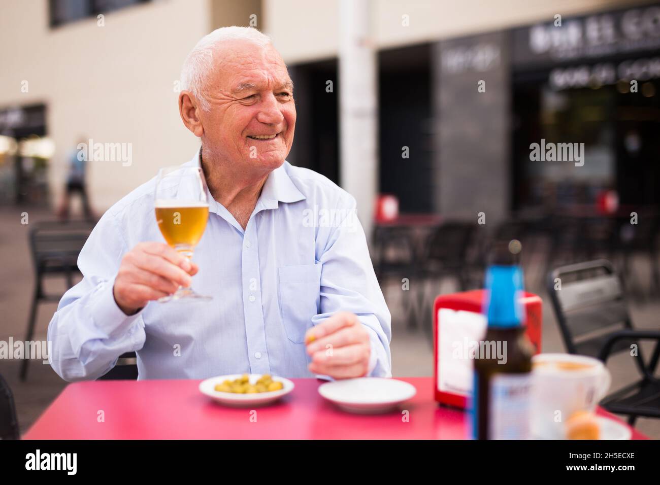 Old man on restaurant terrace with glass of beer Stock Photo - Alamy