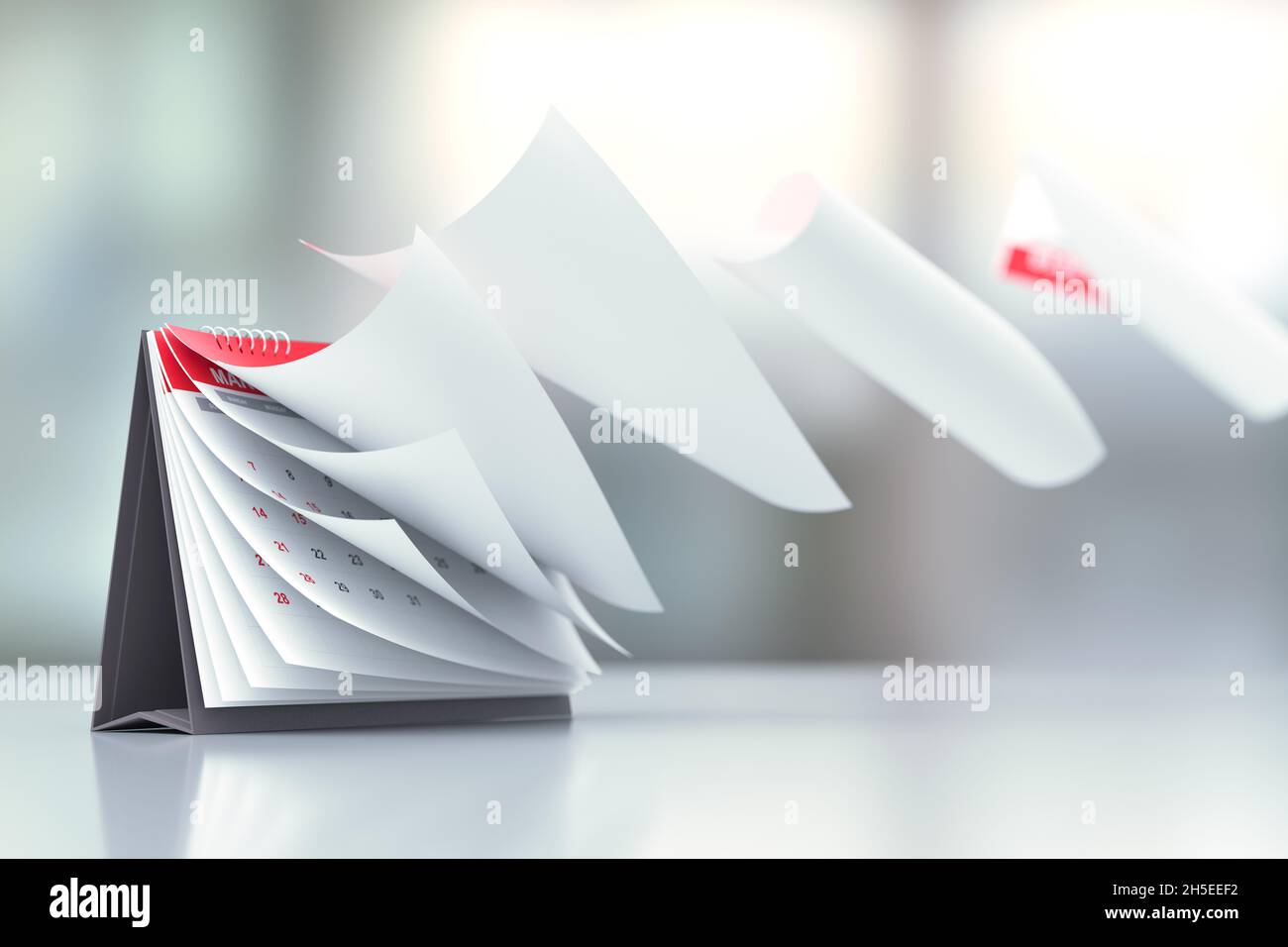 Pages of a red calendar standing over defocused background are flying ...