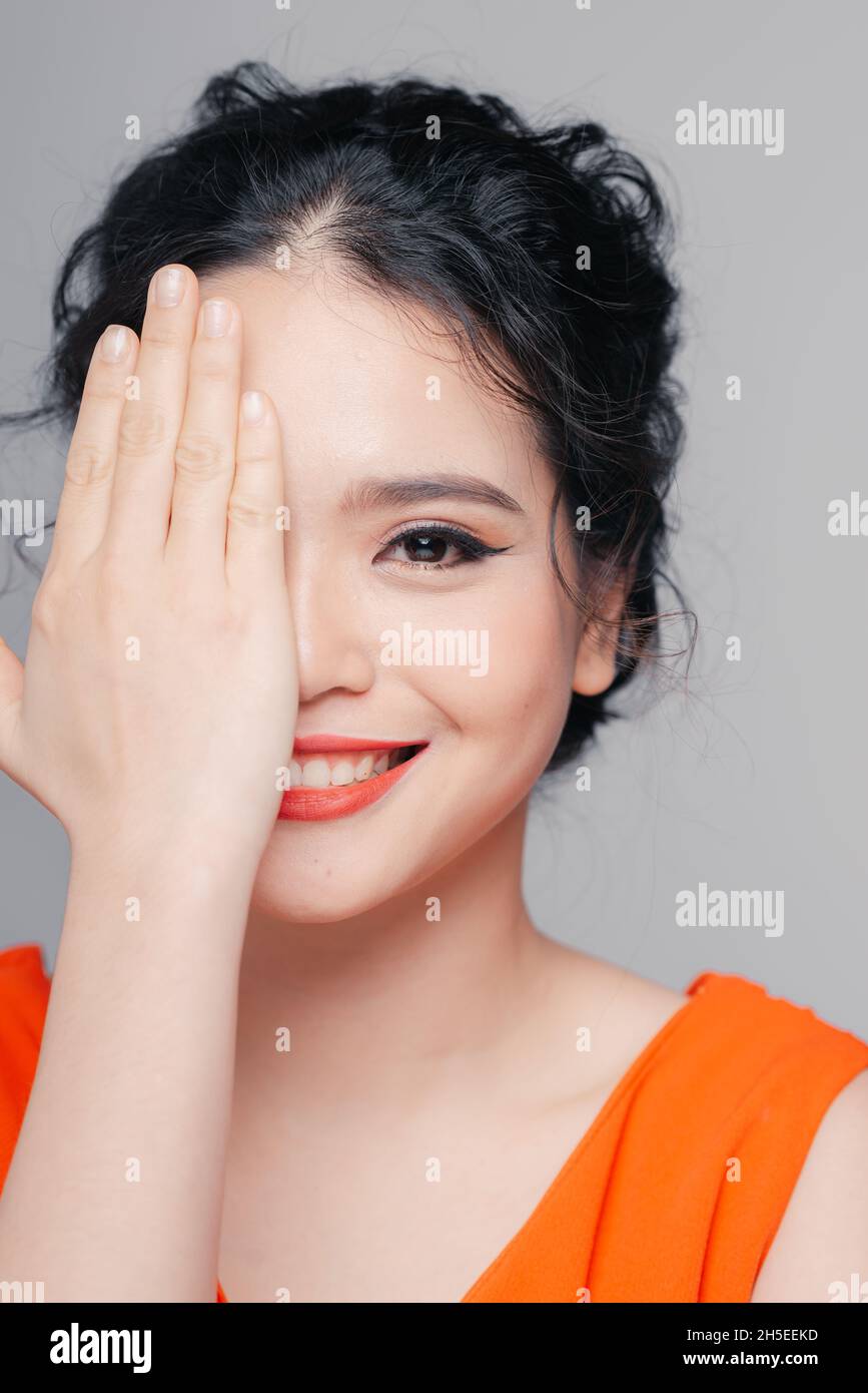 Pretty stylish woman hiding half of face behind hand Stock Photo - Alamy