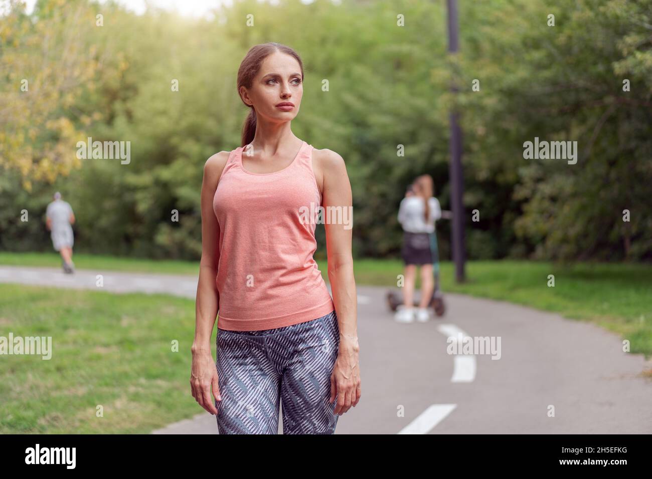 Beautiful athletic woman standing running track in summer park Portrait ...