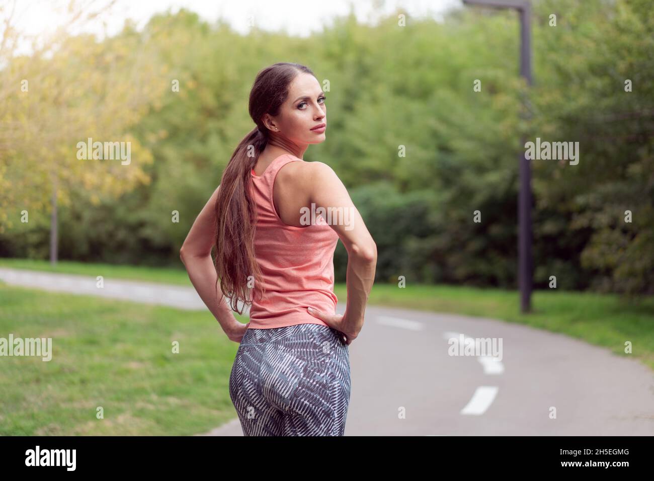 Beautiful athletic woman standing running track in summer park Portrait ...