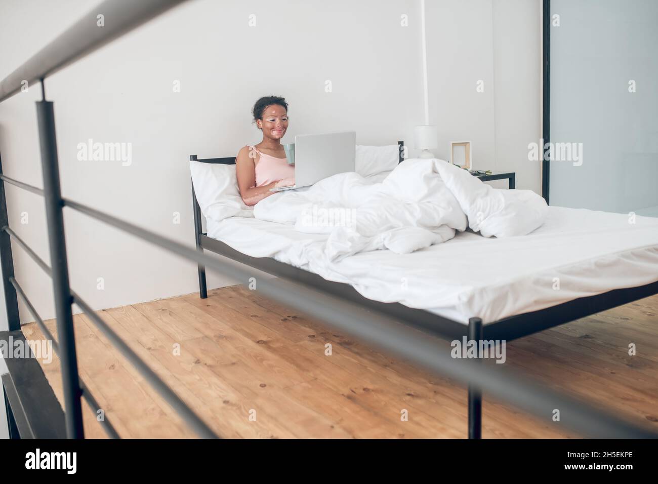 A young woman with a laptop in bed at home Stock Photo - Alamy