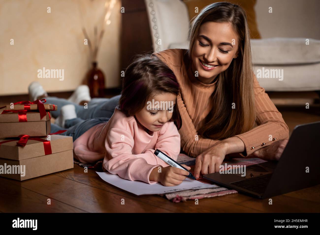 Portrait of cute girl writing letter to Santa with mom Stock Photo - Alamy
