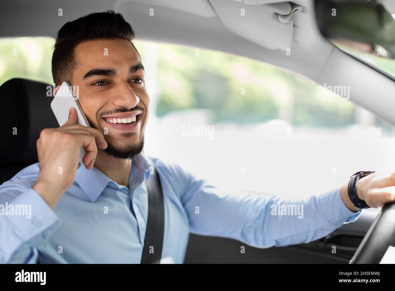 Cheerful arab man talking on cellphone while driving car, closeup Stock ... Cheerful arab man talking on cellphone while driving car, closeup Stock ...