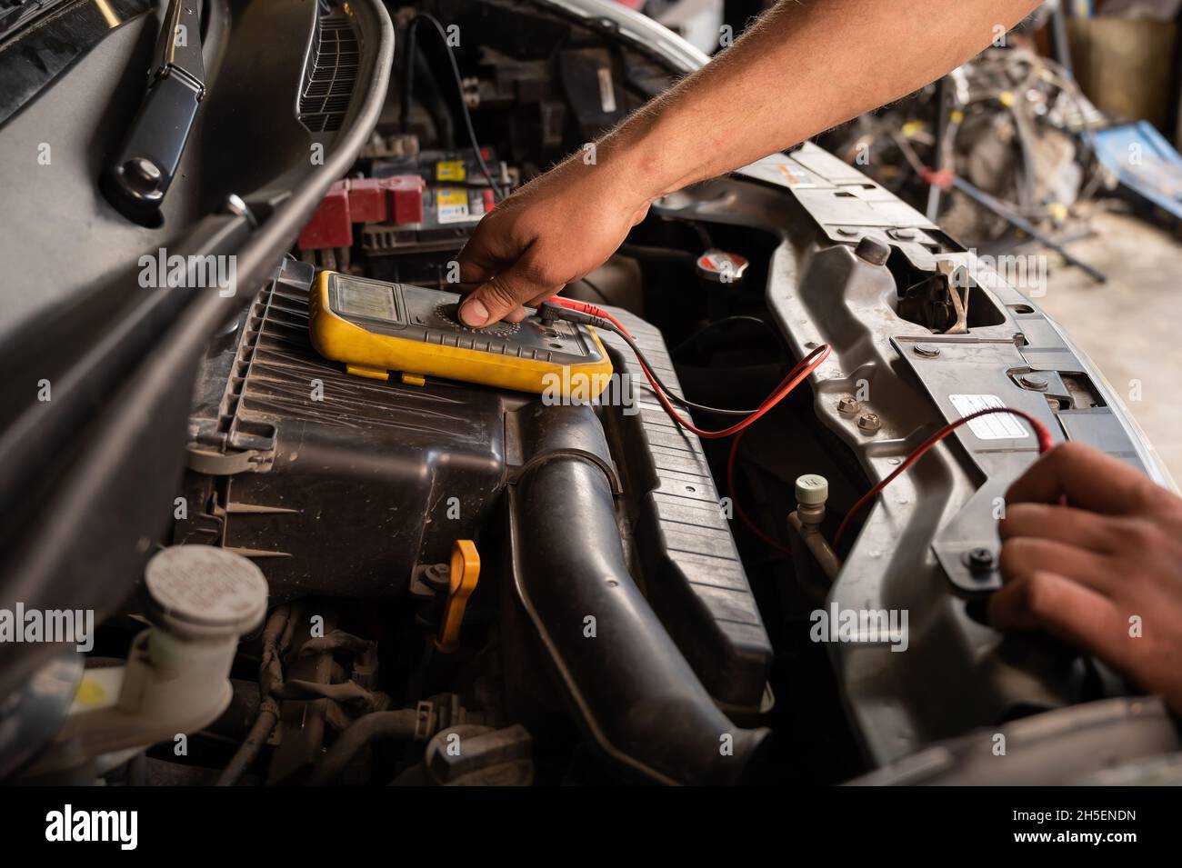 Auto mechanic measures voltage with multimeter Stock Photo - Alamy