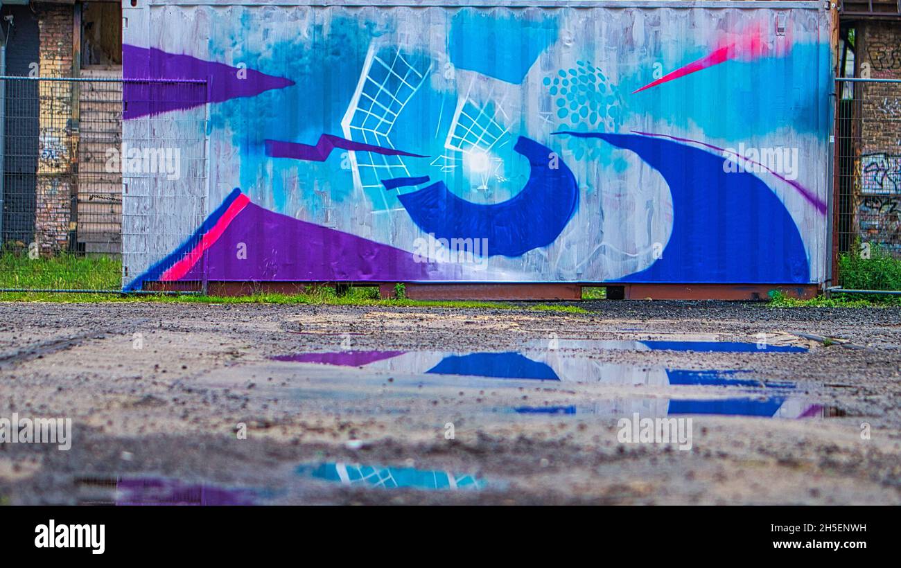 graffiti on a wall reflected in a puddle. Ground level view Stock Photo ...