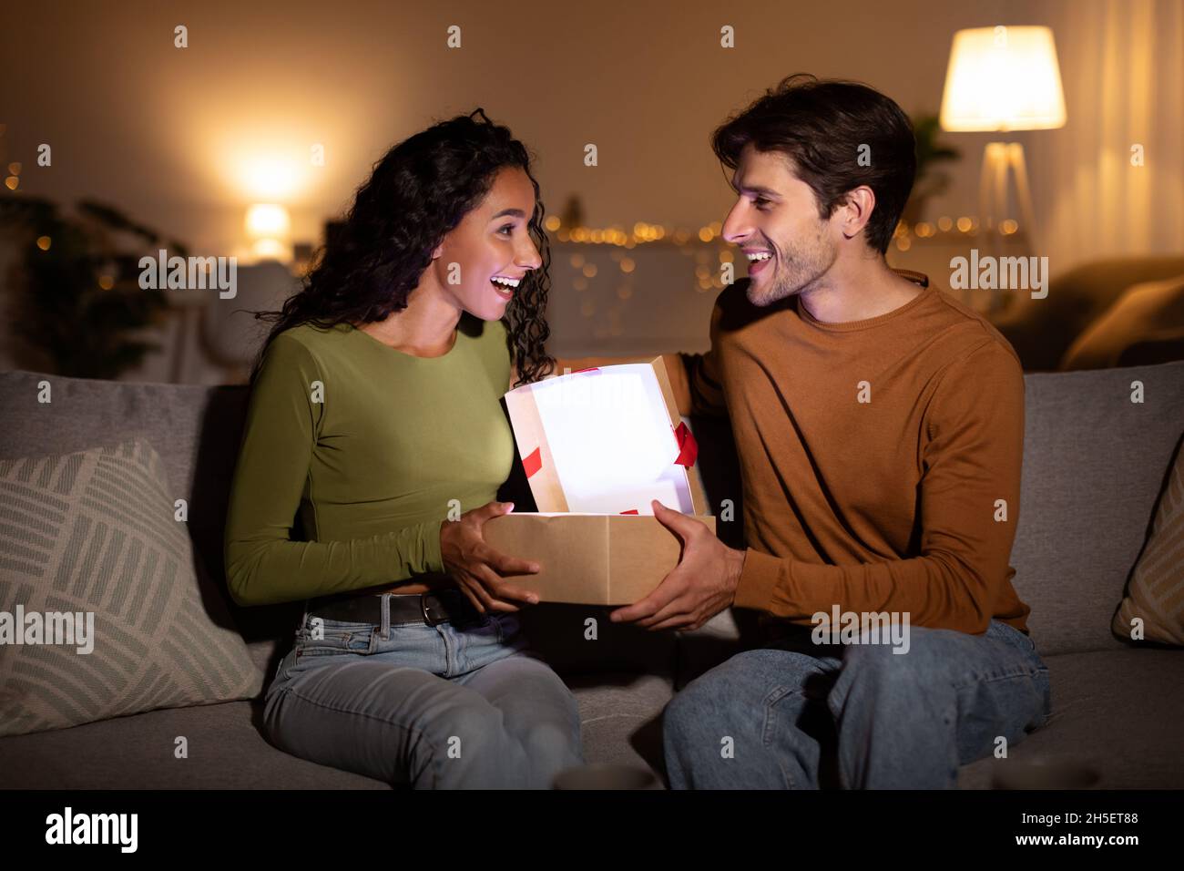 Young husband opening birthday gift hi-res stock photography and images ...