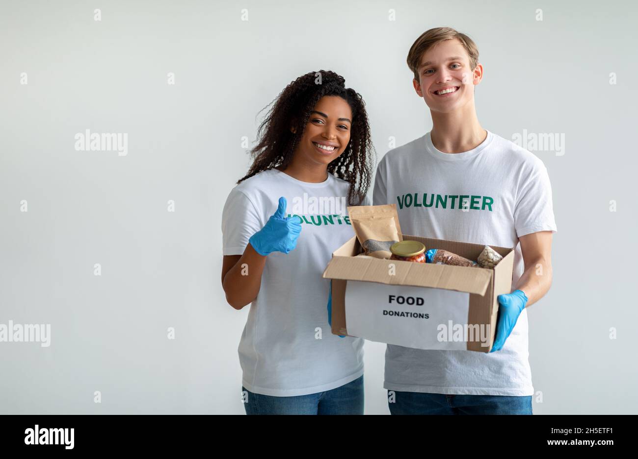 Charity organization. Mixed race volunteers holding food donations box ...