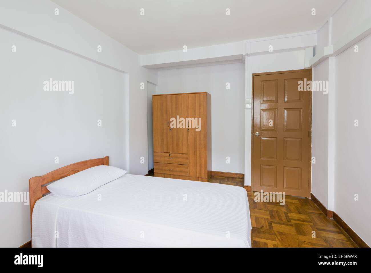 Simple modest bedroom with bed and closet furniture Stock Photo - Alamy