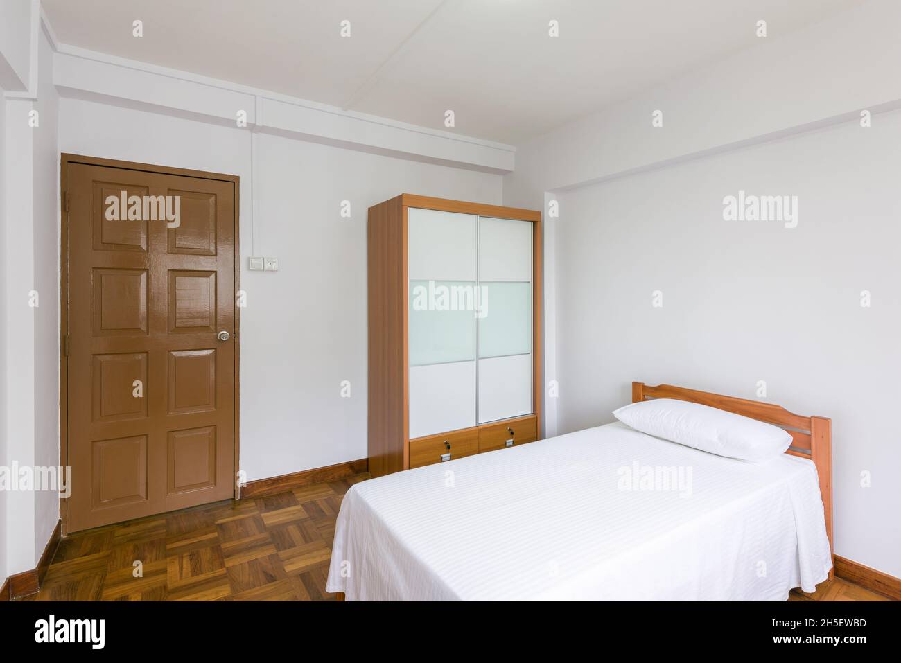 Simple modest bedroom with bed and closet furniture Stock Photo - Alamy