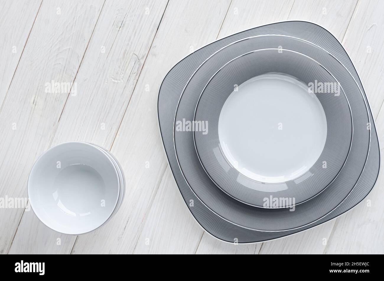 The modern classical porcelain set of plates stands on a white wooden ...