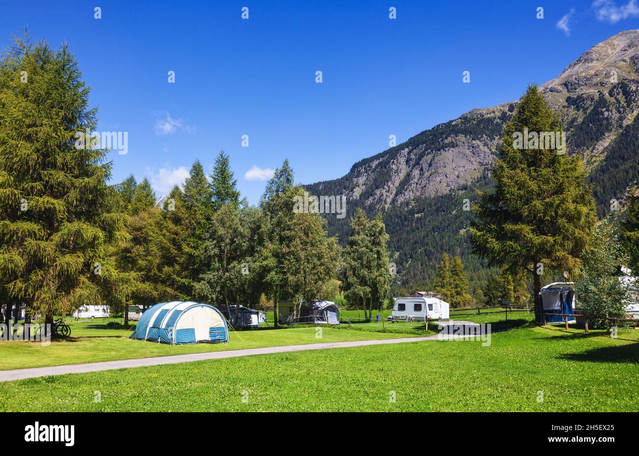 Tents and Camper trailers at a campsite in the Swiss Alps on a sunny ...