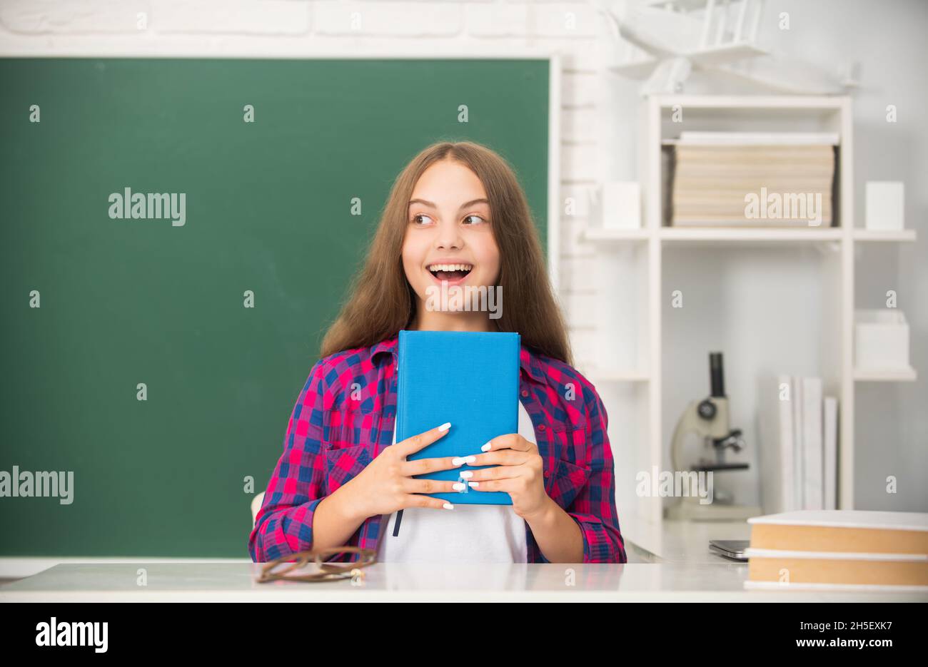 amazed kid do homework with book. teenager student. modern education ...