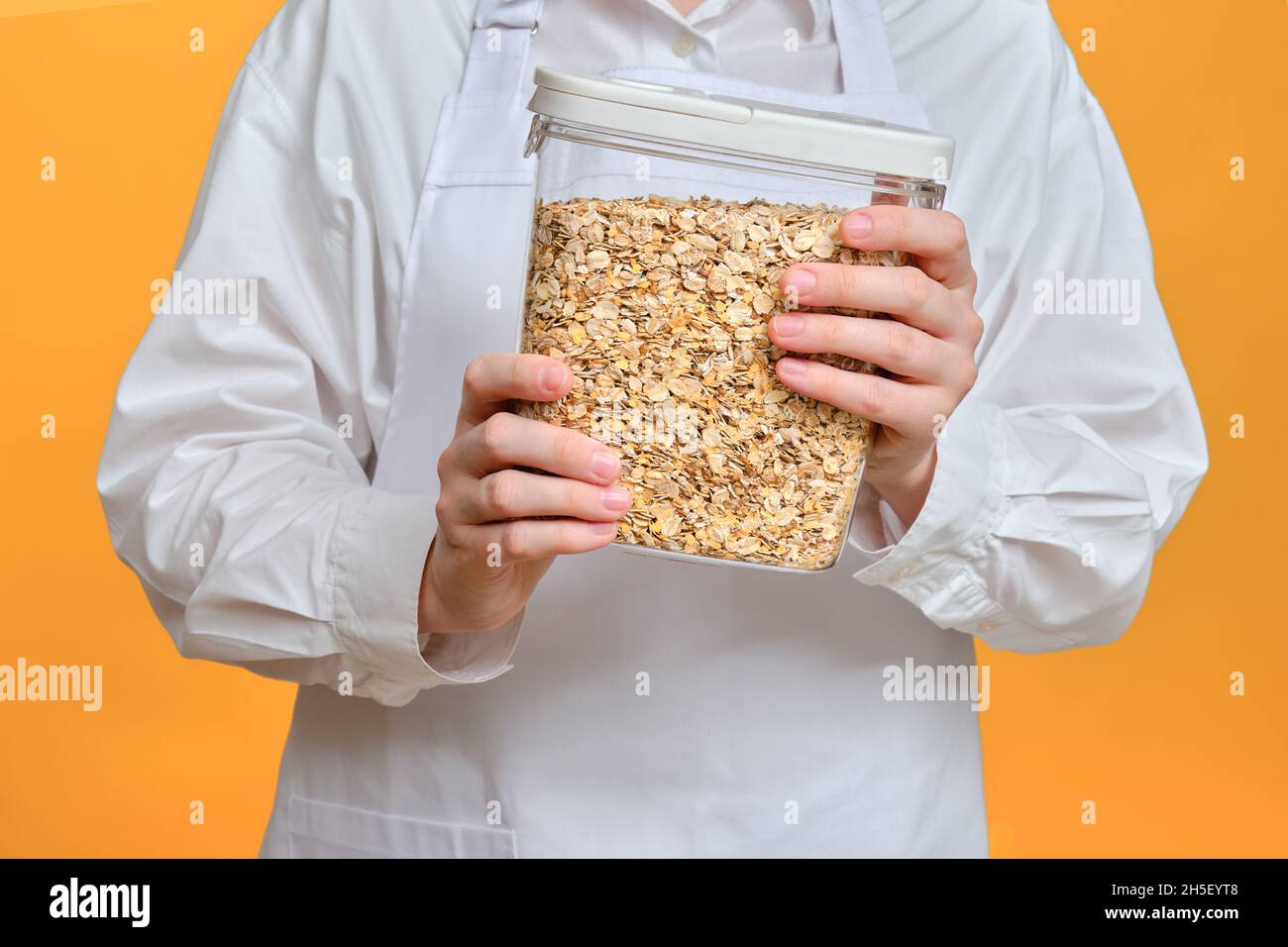 Man chef with container with cereal for porridge in hand on studio ...