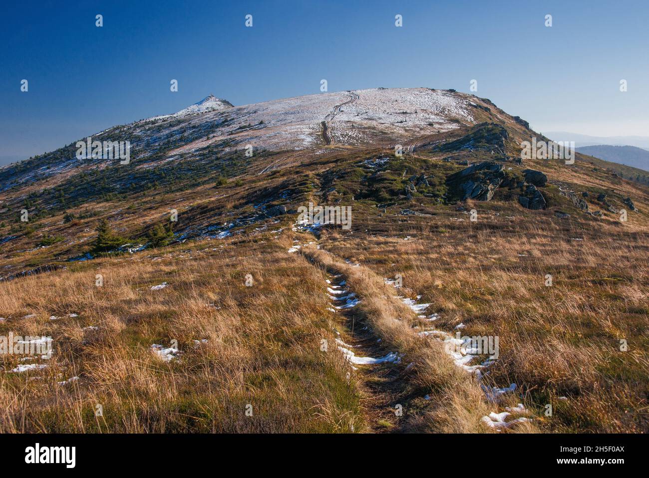 View of hills of Water Dividing ridge covered in dried grass and snow ...