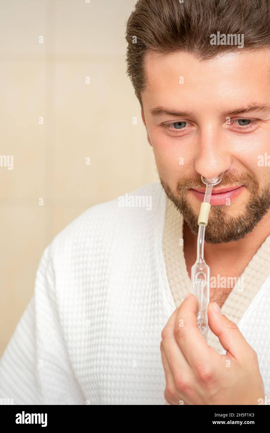 Young caucasian man receiving nasal inhalation Maholda with essential ...
