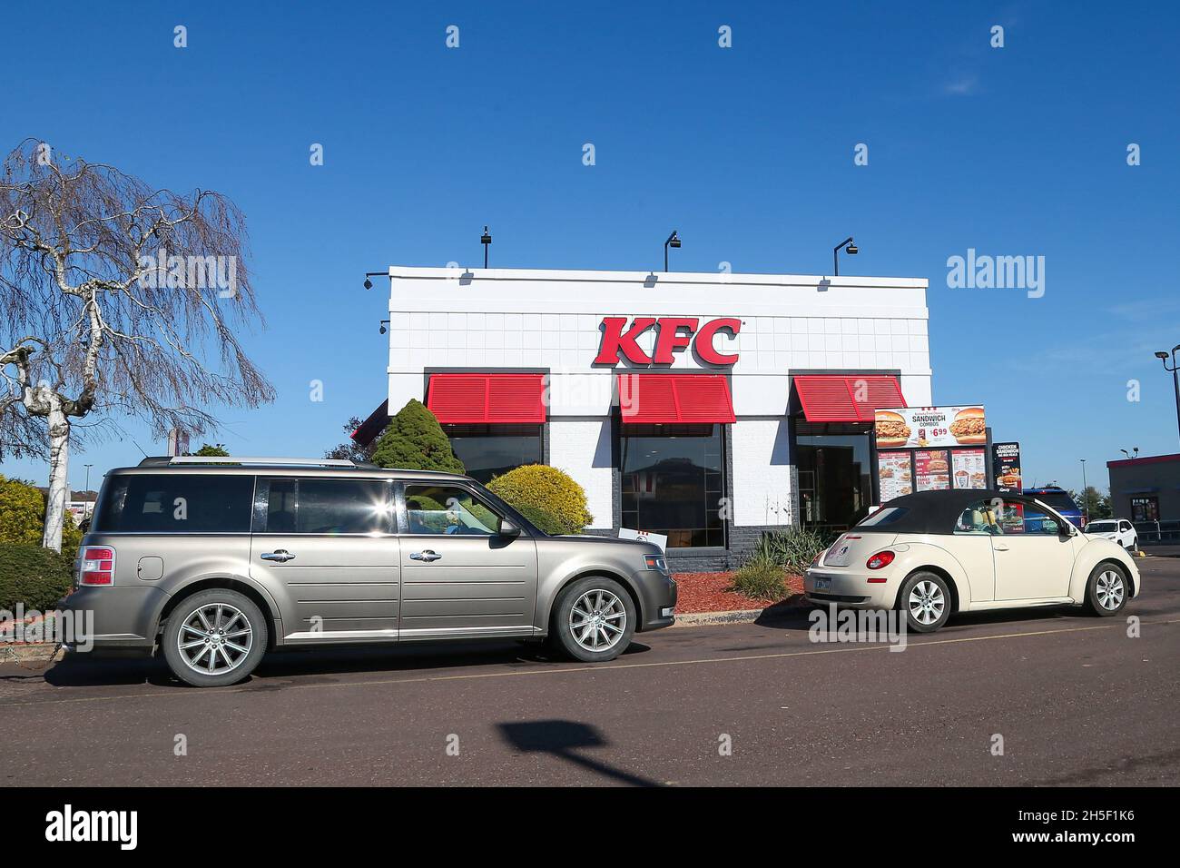 Cars wait in a line at a KFC (Kentucky Fried Chicken) drive-thru in ...