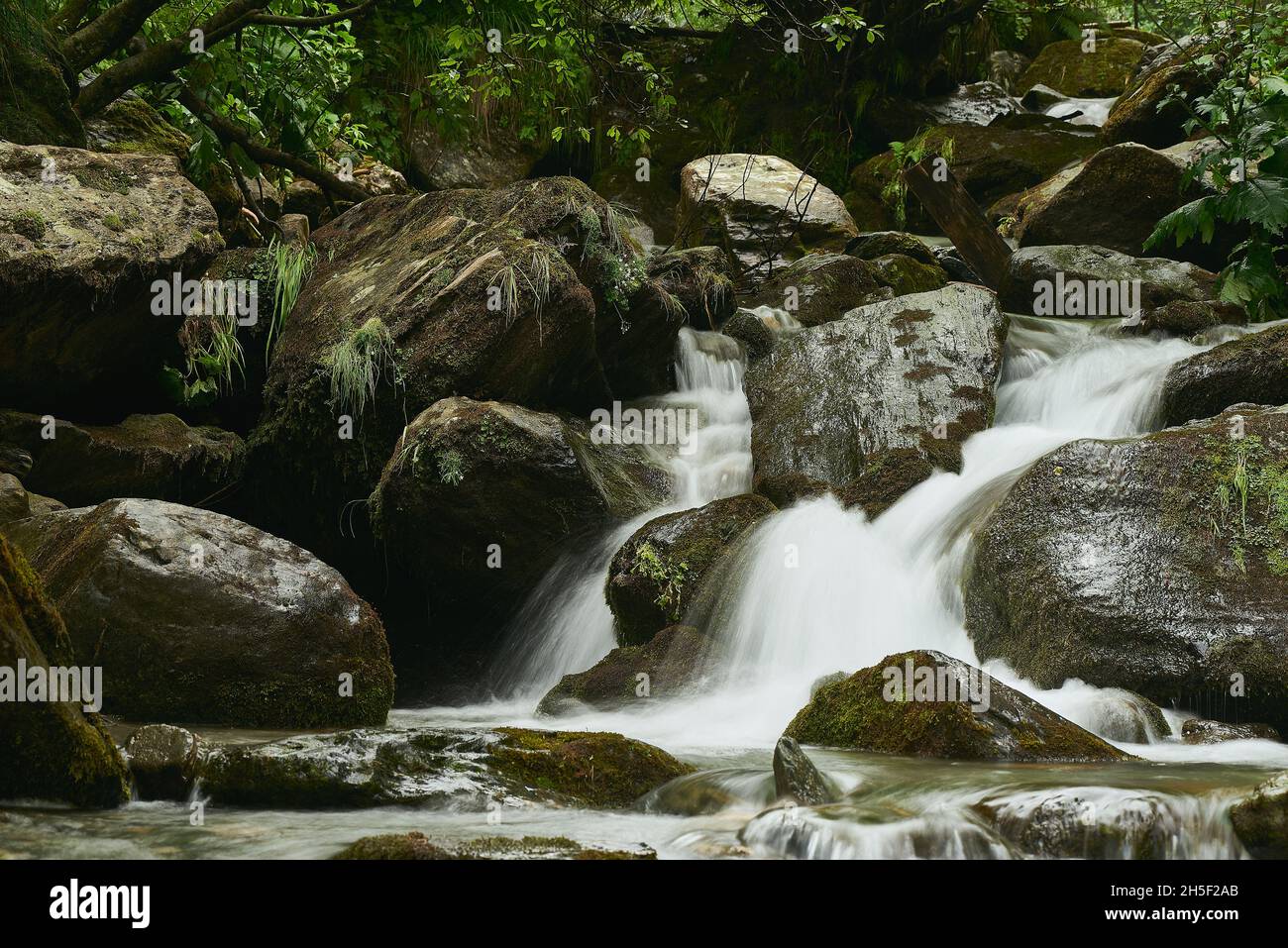 Small waterfall flowing over the rocks Stock Photo - Alamy